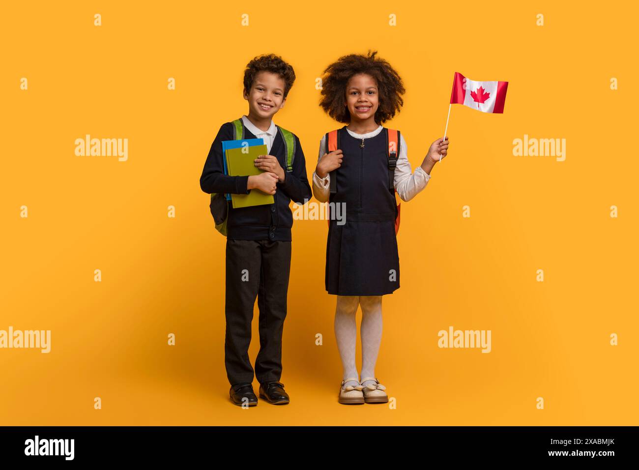 Two Children Wearing School Uniforms Holding Books and Canadian Flag ...