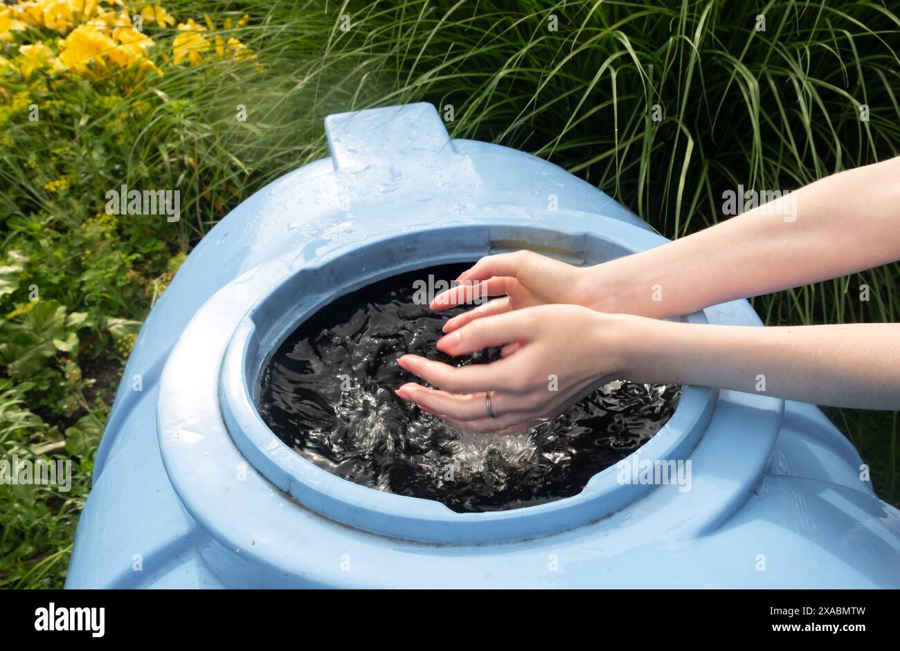 water collection tank under a roof with a drain. Faceless girl washes ...