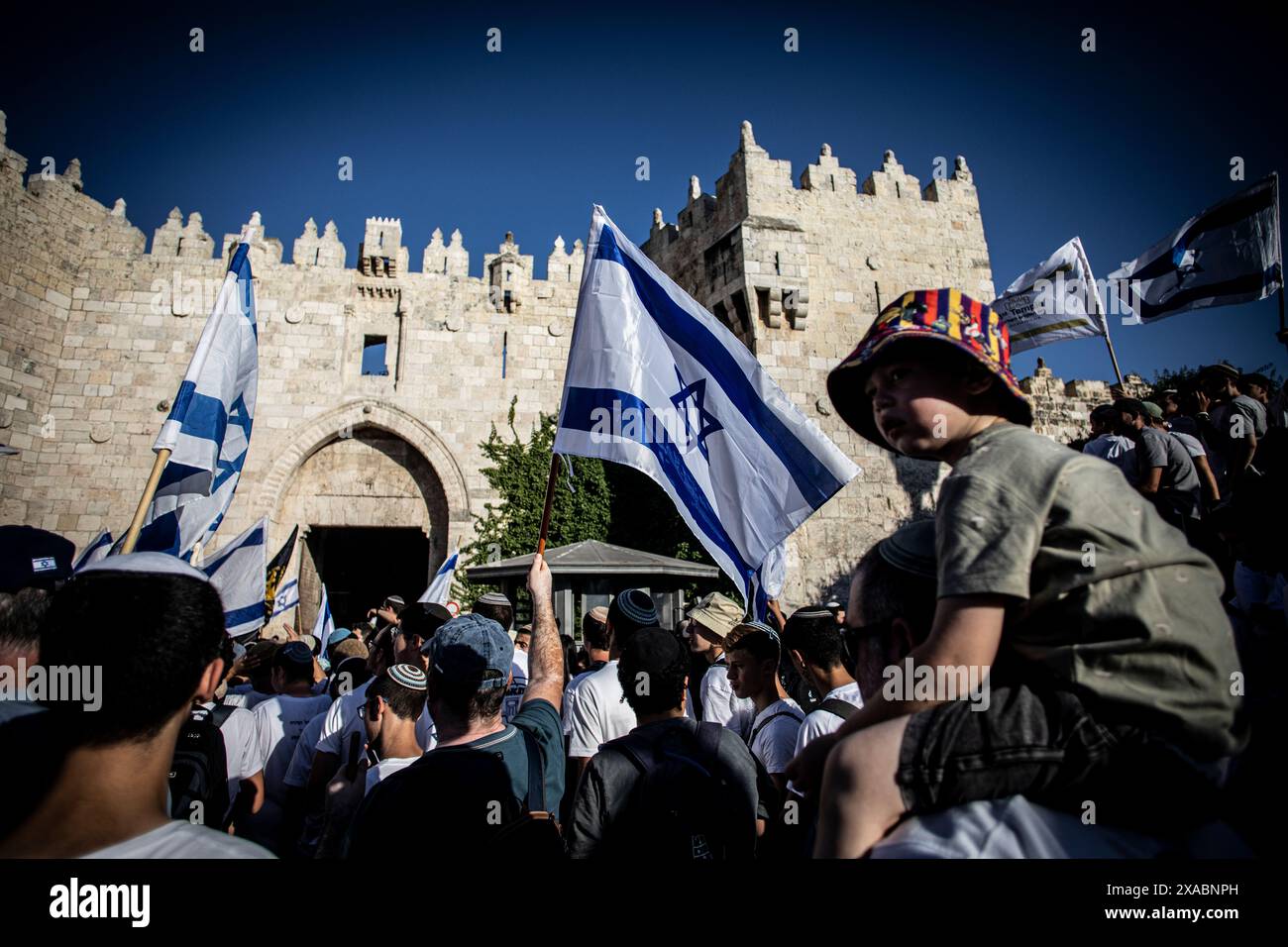 A toddler sits on his parent shoulders as Israeli right wing youths ...