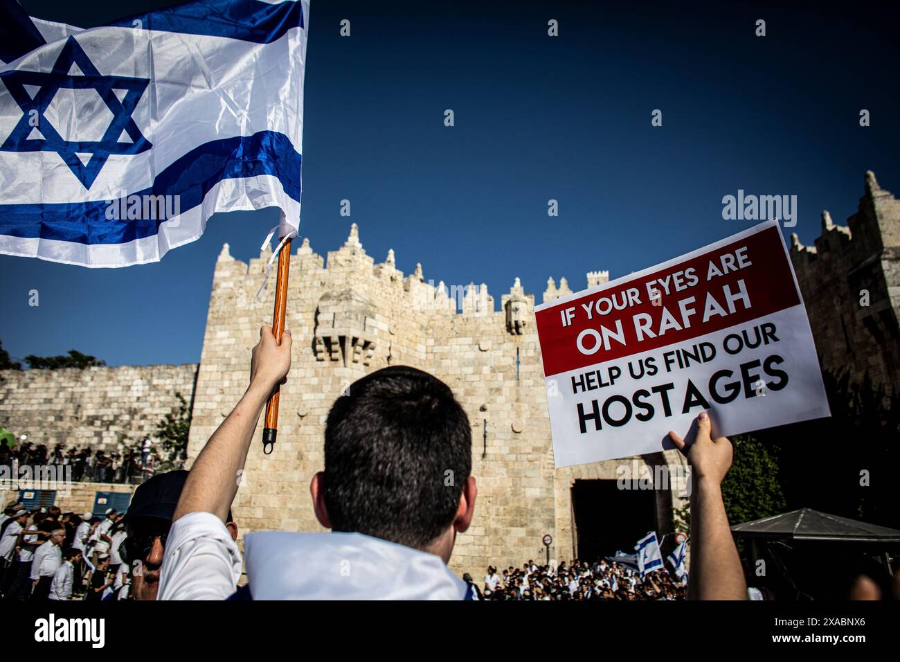 An Israeli man holds a poster and the Israeli flag outside Damascus ...