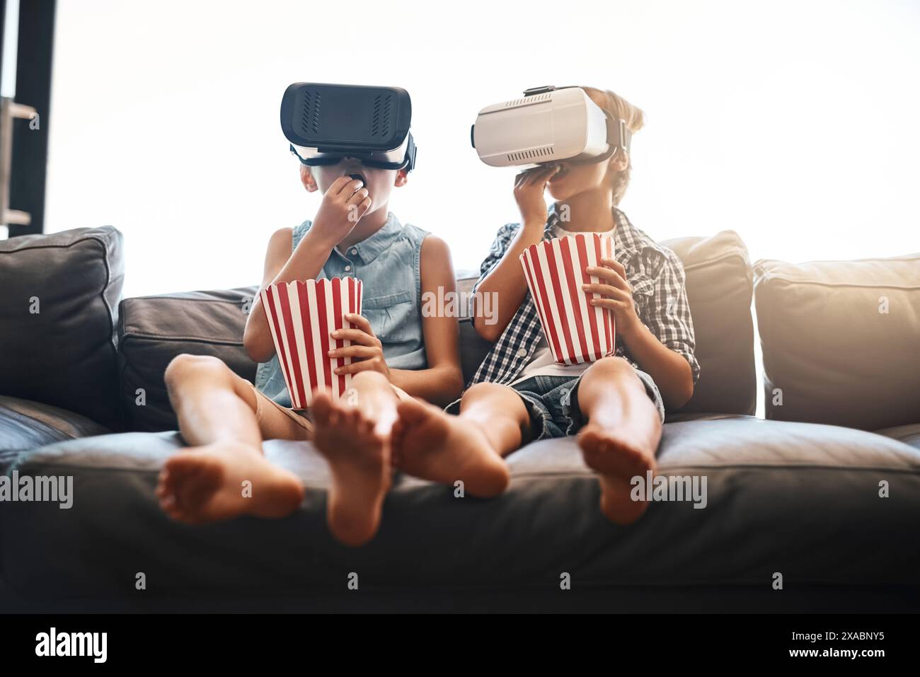 Children, popcorn and virtual reality headset in home of cyber ... Children, popcorn and virtual reality headset in home of cyber ...