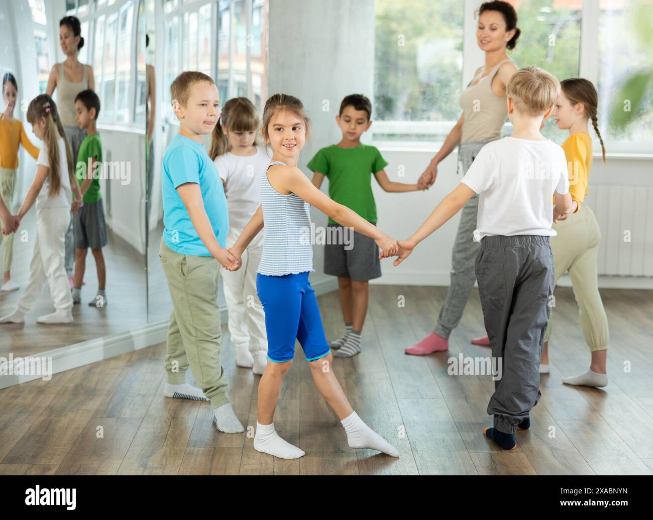 Children holding hands and dancing in round dance in choreography class ...