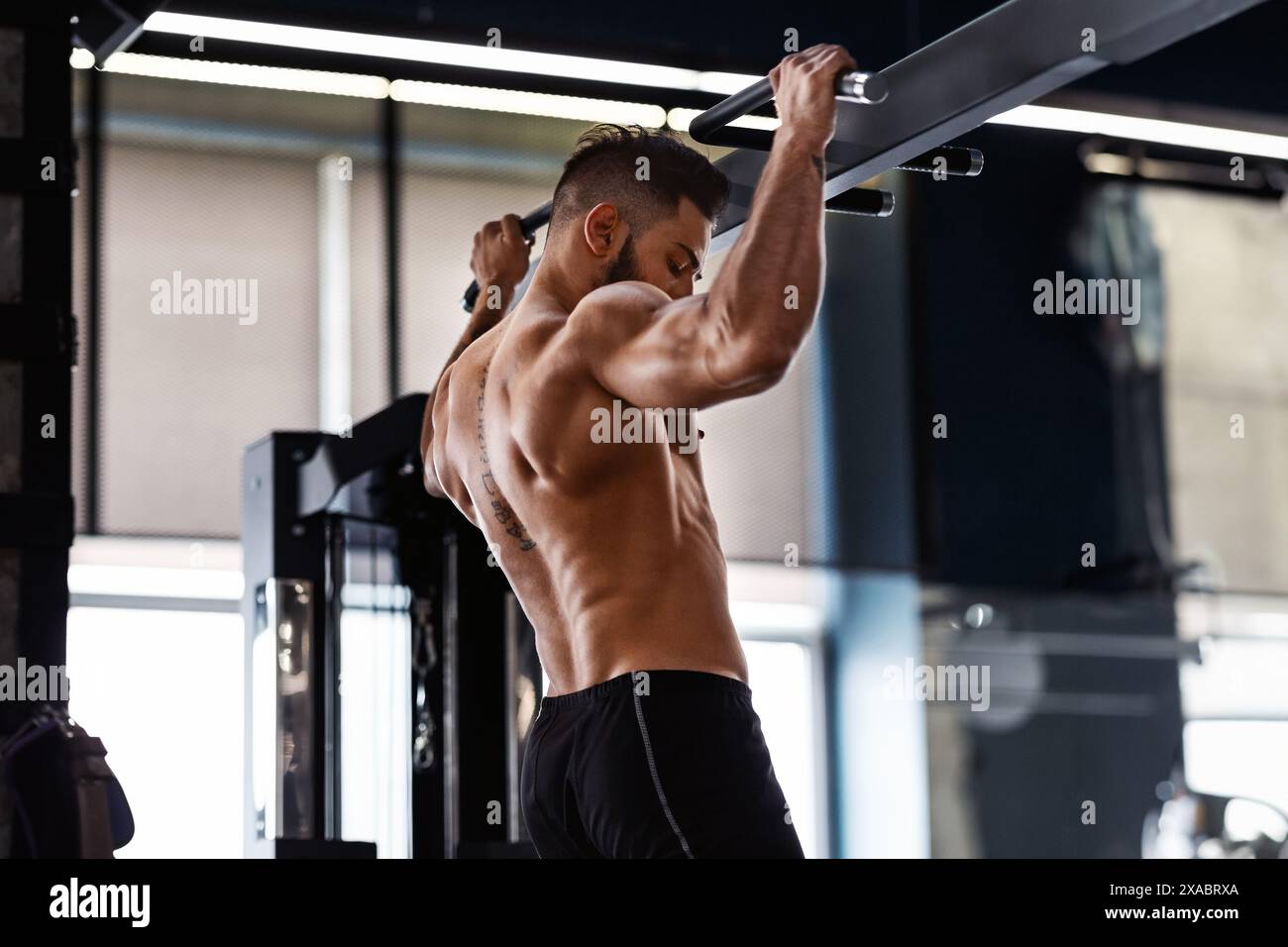 Man Doing Pull-Ups in a Gym Stock Photo - Alamy