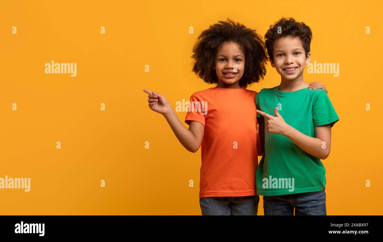 Two Kids Pointing to the Right on Yellow Background Stock Photo - Alamy