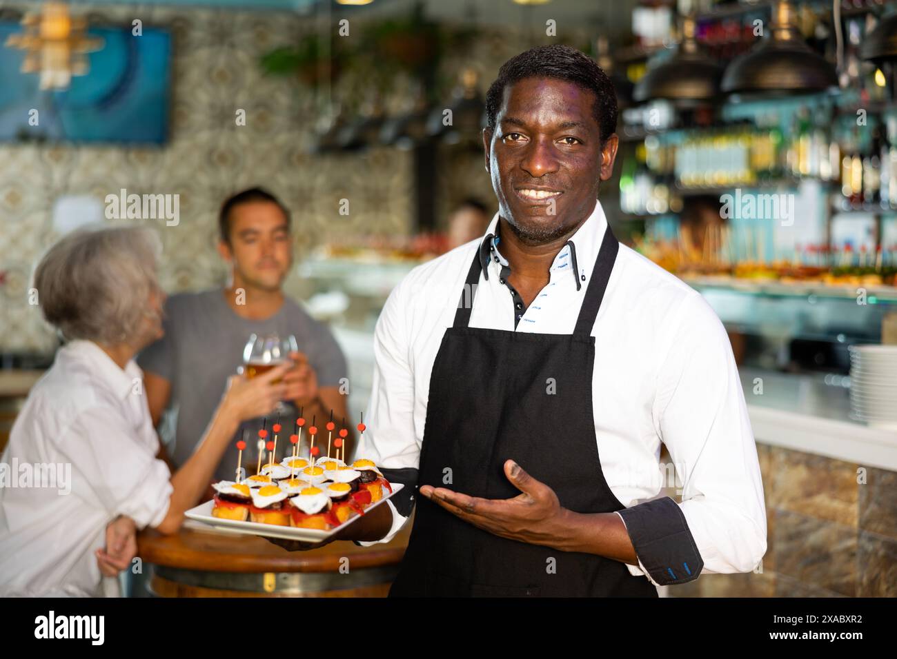 Professional african american waiter holding serving tray for ...