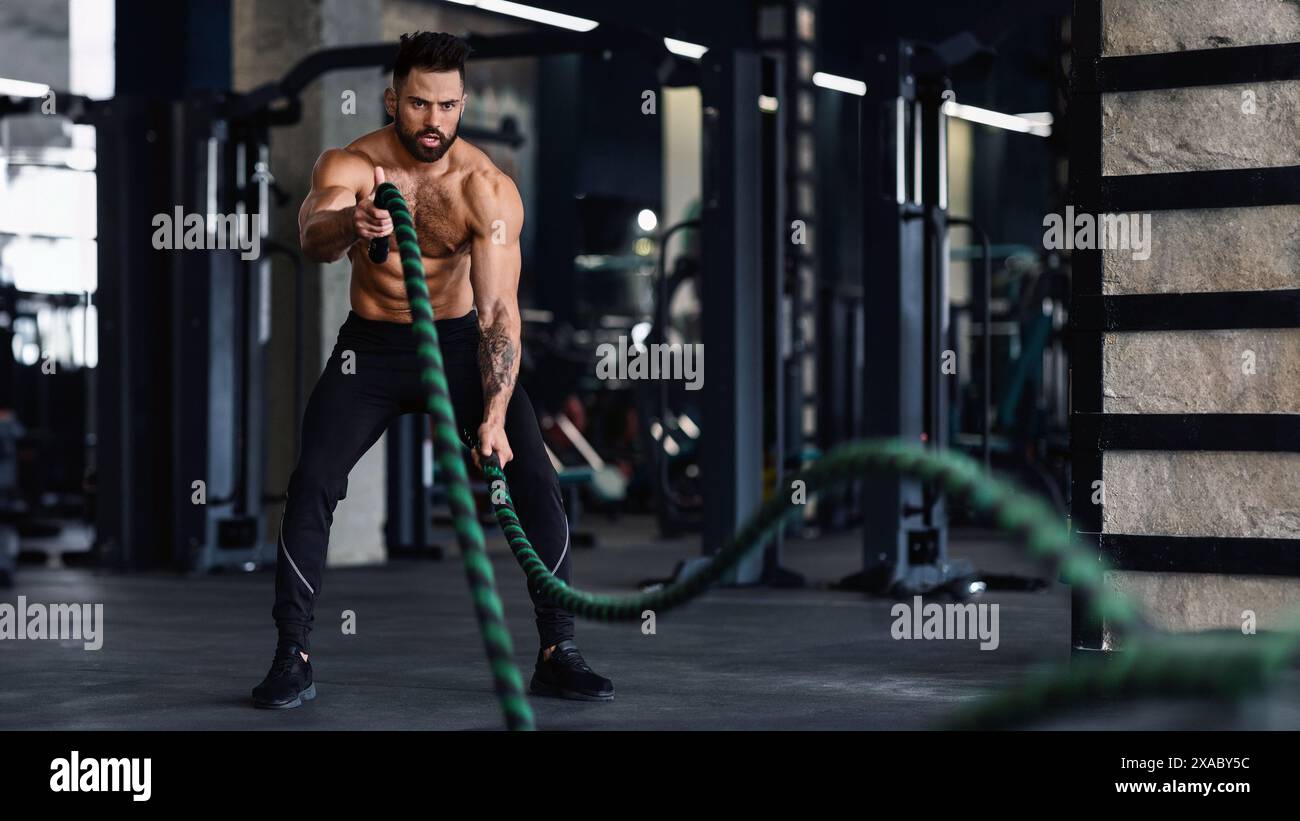 Man Working Out With Battle Ropes in Gym Stock Photo - Alamy
