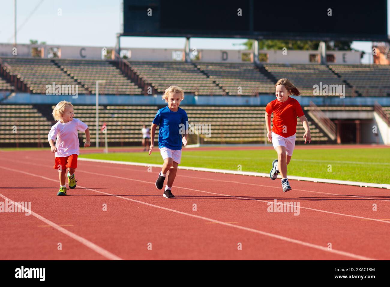Child running in stadium. Kids run on outdoor track. Healthy sport ...