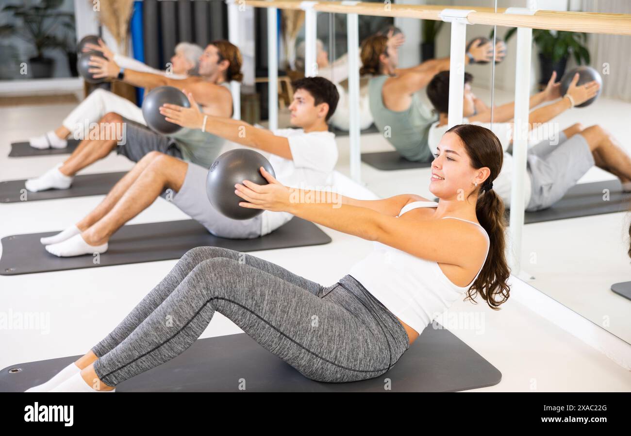 Group of different people doing exercises with ball Stock Photo - Alamy