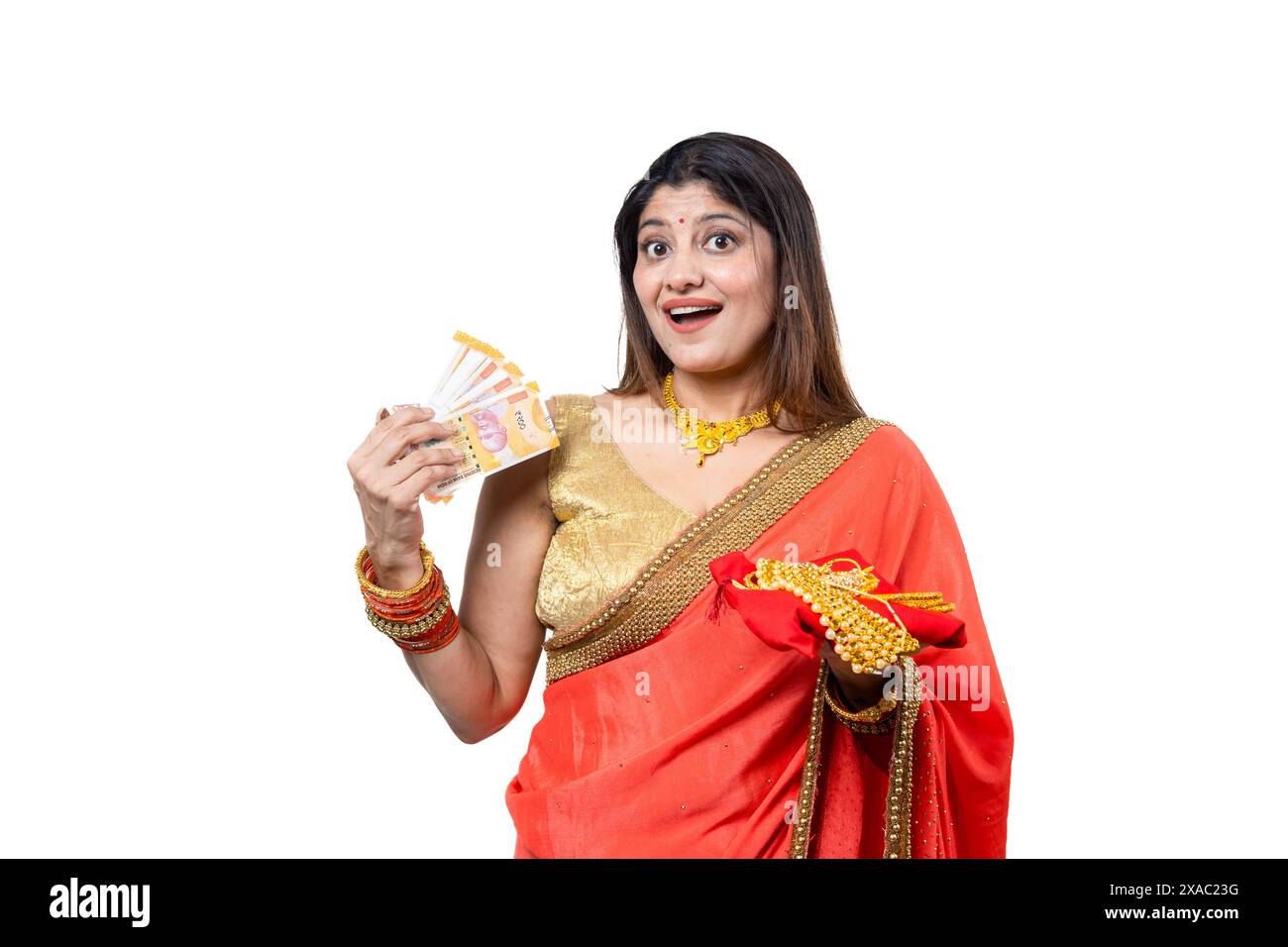 Happy young Indian woman wearing red saree holding gold jewelry ...