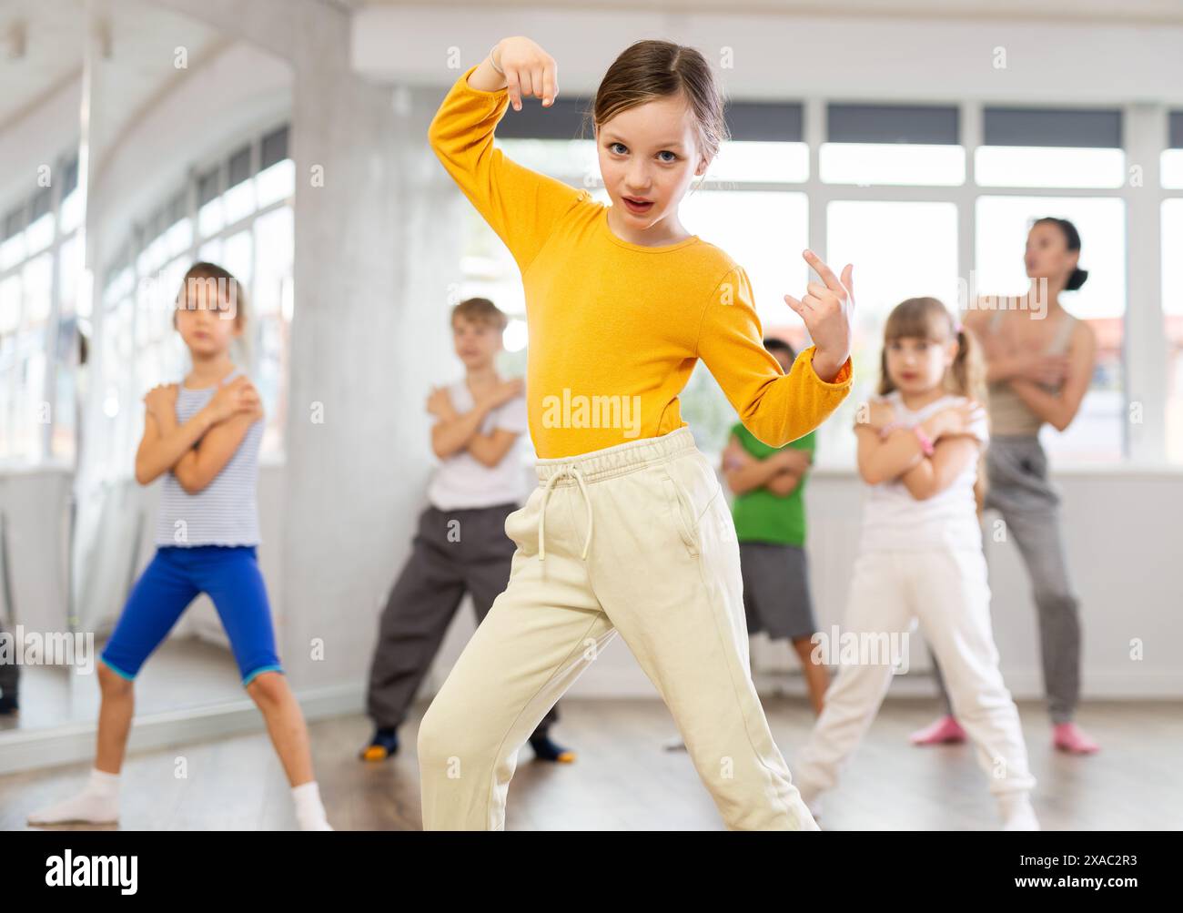 Group of preteen girls and boys enjoying active dance movement in ...