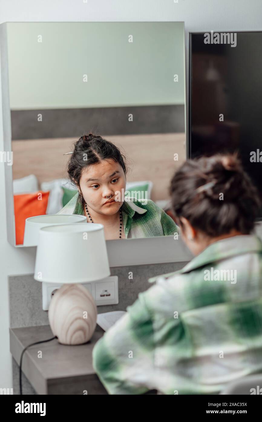 asian girl s expression in the mirror suggests a silent conversation ...