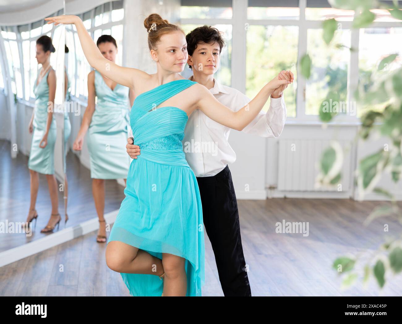 Dance teacher teaches a girl and a boy couples ballroom dancing Stock ...