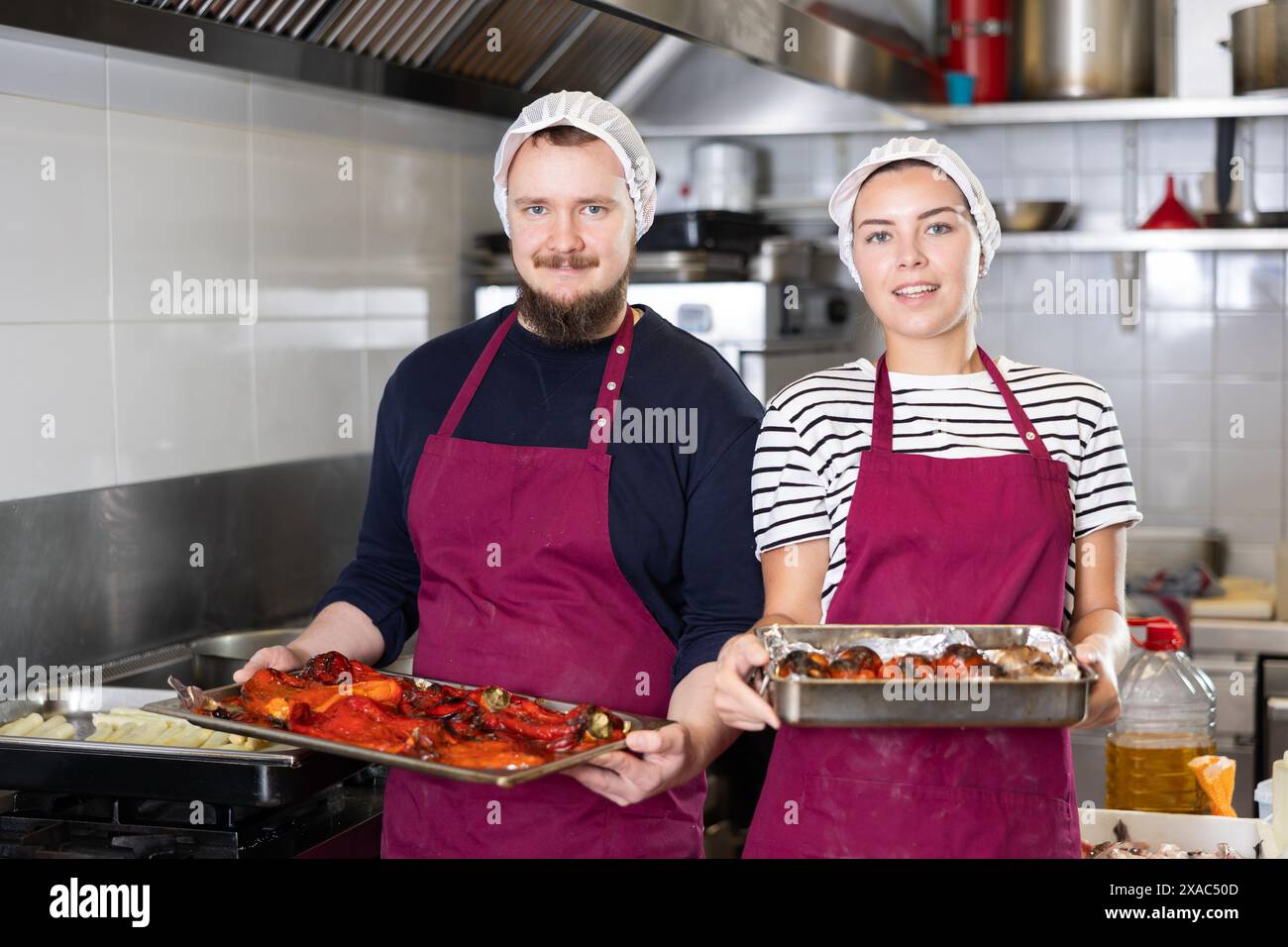 Portrait of two chefs with ready-stewed peppers in kitchen Stock Photo ...