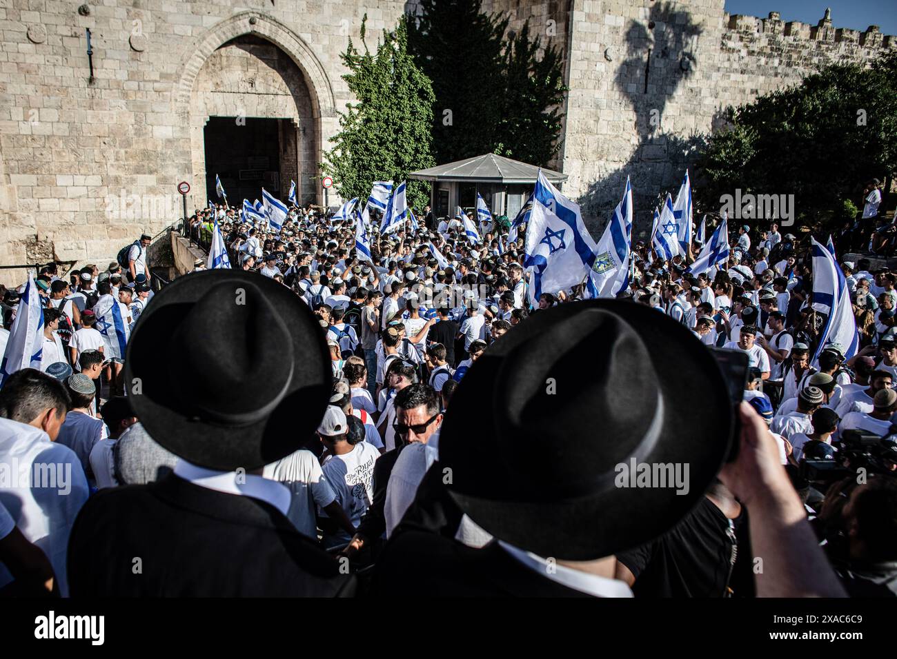 Ultra orthodox Jewish men look at Israeli right wing youths waving ...