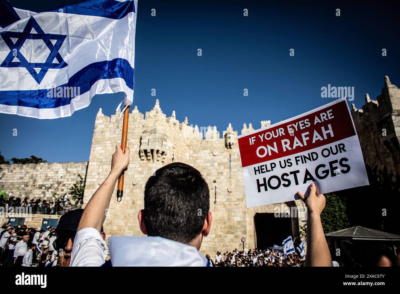 An Israeli man holds a poster and the Israeli flag outside Damascus ...