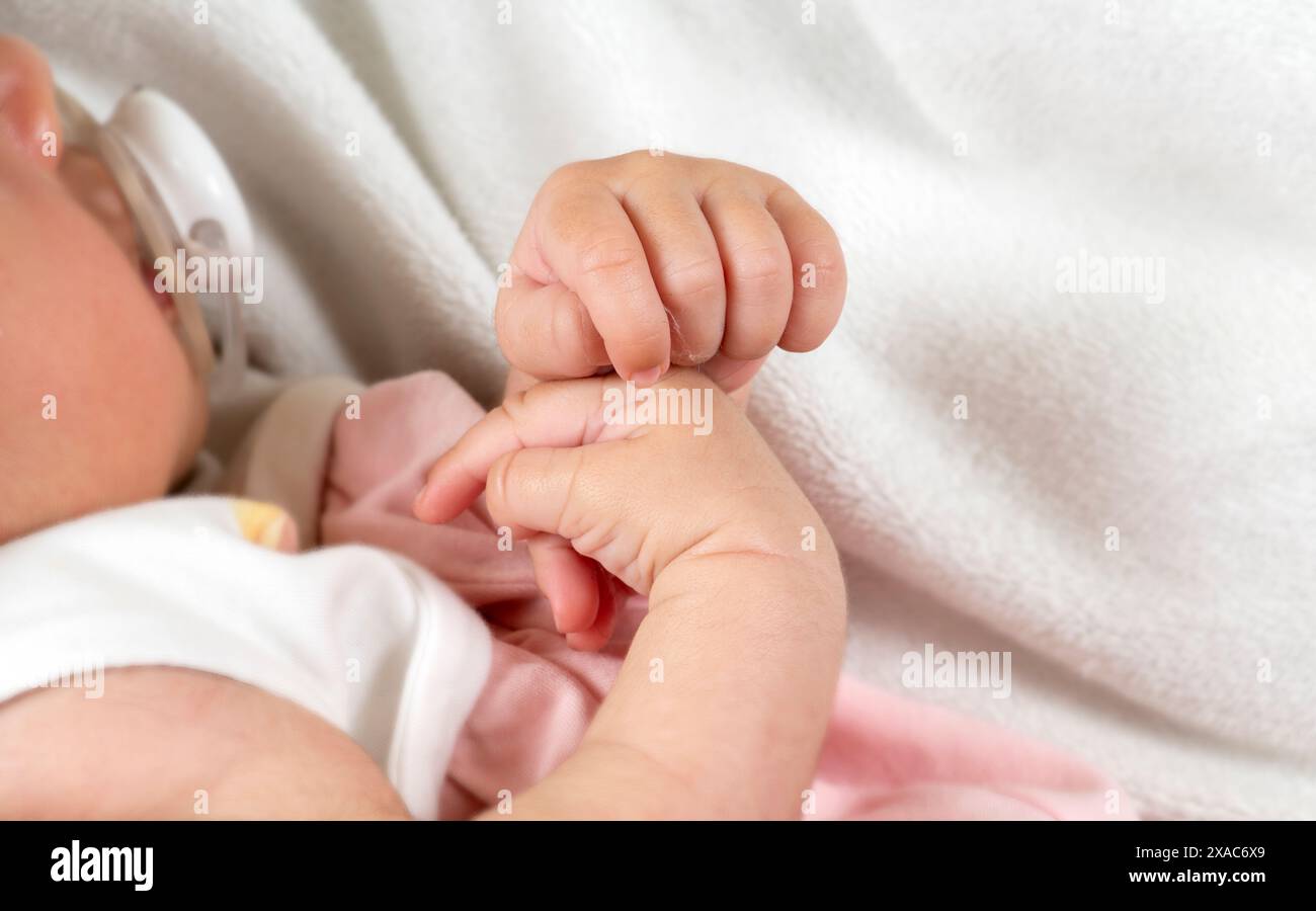 Pacified Serenity: Baby Holding Pacifier with Tender Hands Stock Photo ...