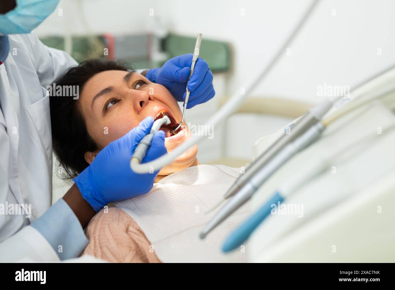 African american dentist professional filling teeth for woman patient ...