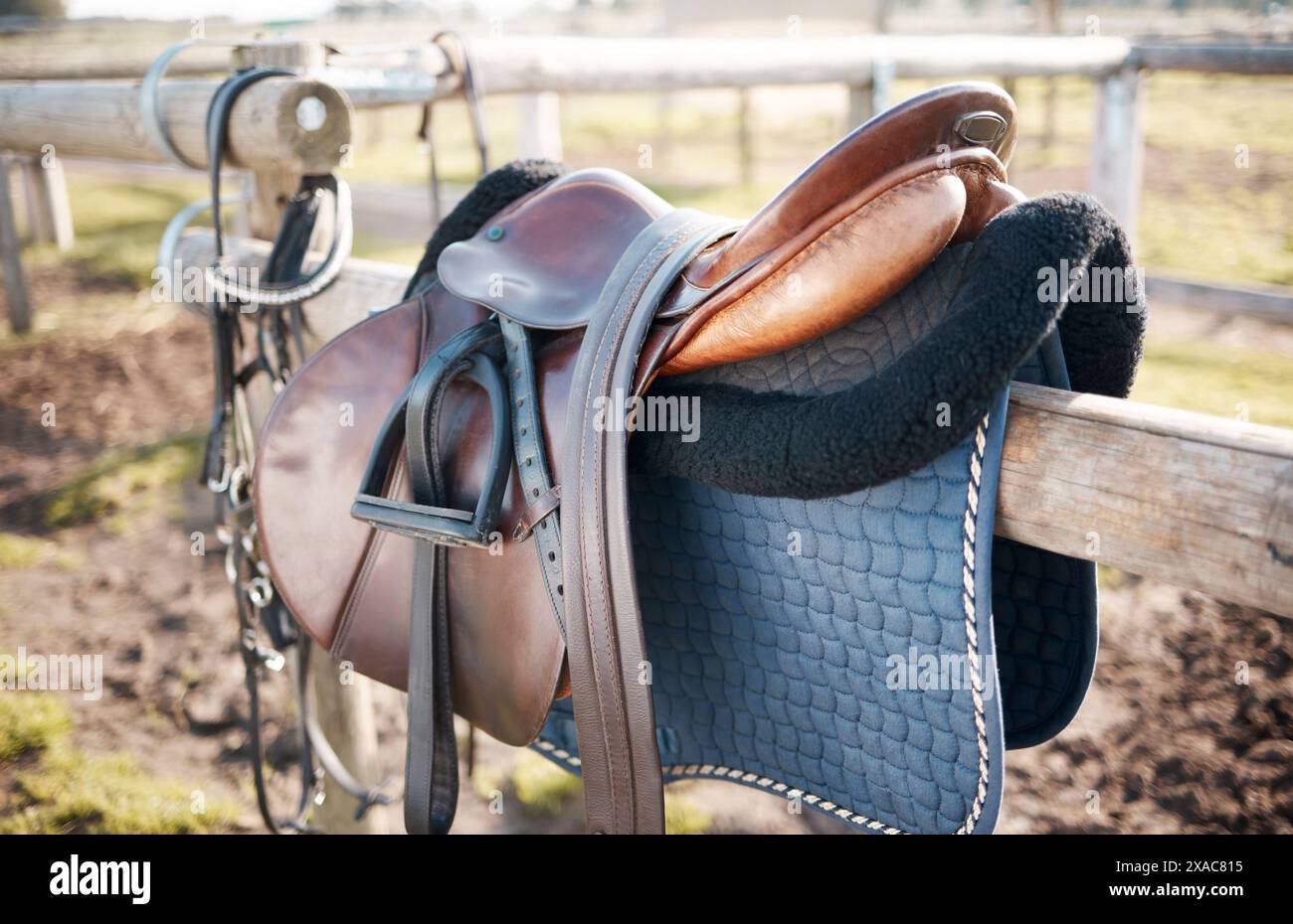 Saddle, countryside and farm on stable fence for riding or equestrian ...