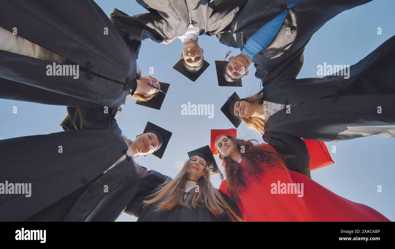 College graduates in a circle stand hugging each other Stock Photo - Alamy
