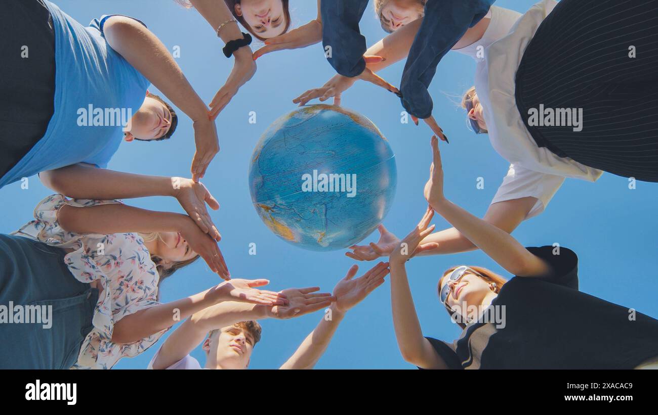 Students make a circle around the globe of the world. The concept of ...