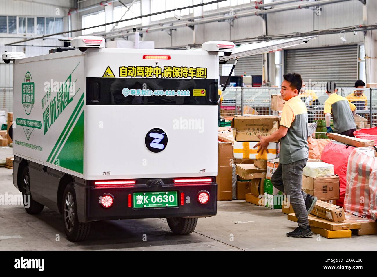 ORDOS, CHINA - JUNE 6, 2024 - A staff member loads express items for a ...