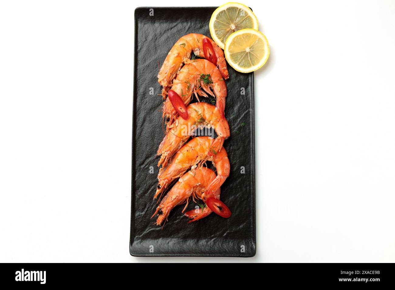 Large cooked king prawns on a black plate. Isolated background Stock ...