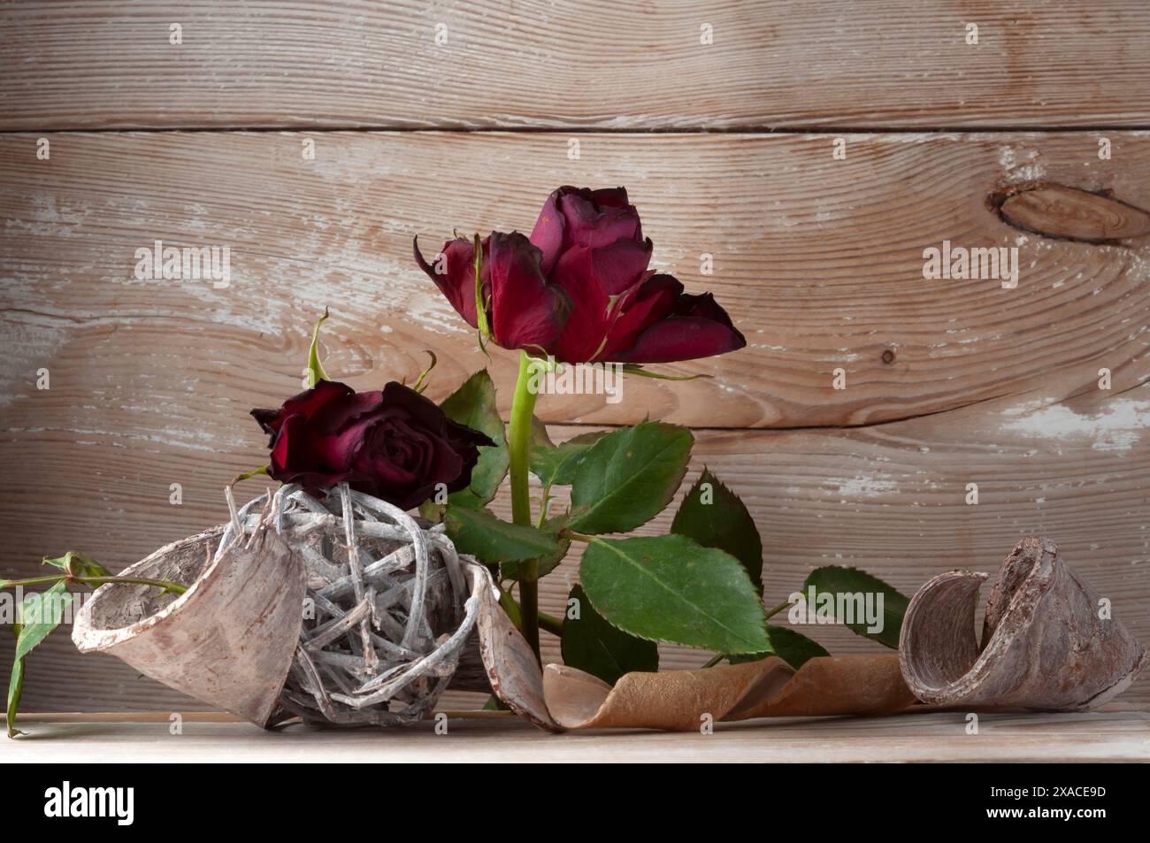 decorative objects made of wood and wicker, fading red rose on a ...