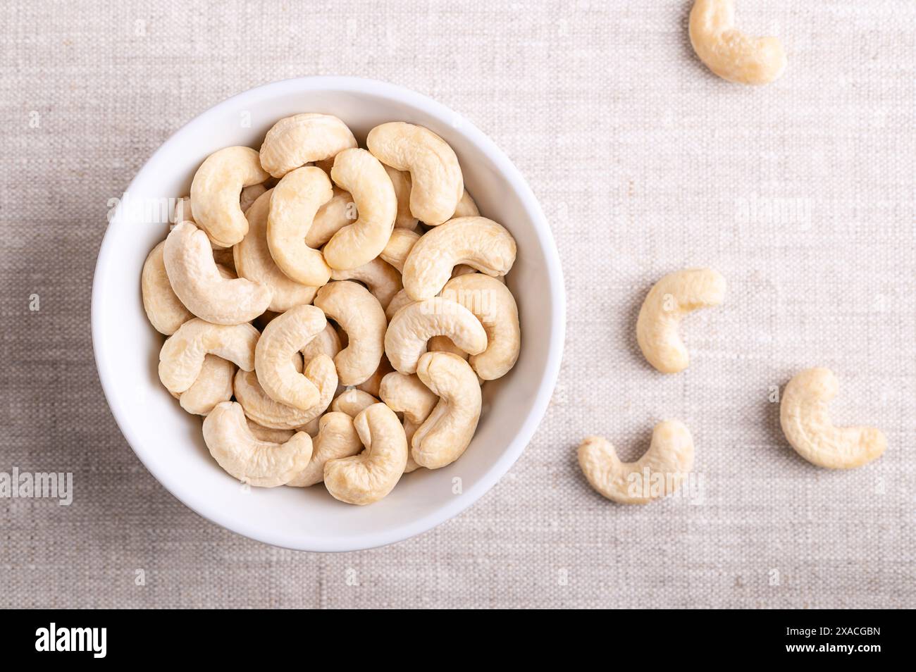 Cashew nuts, raw cashews in a white bowl on linen fabric. Seeds of ...
