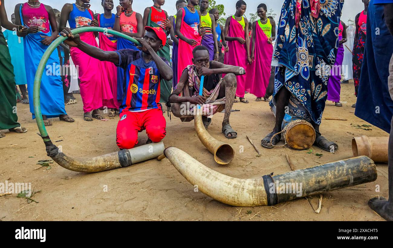 Men making music from cow horns at a traditional Dinka wedding, Bor ...