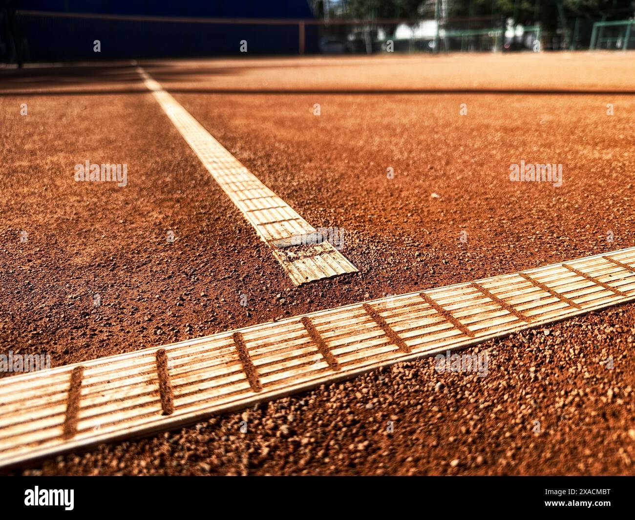 Bottom perspective view of outdoor clay tennis court and black net with ...