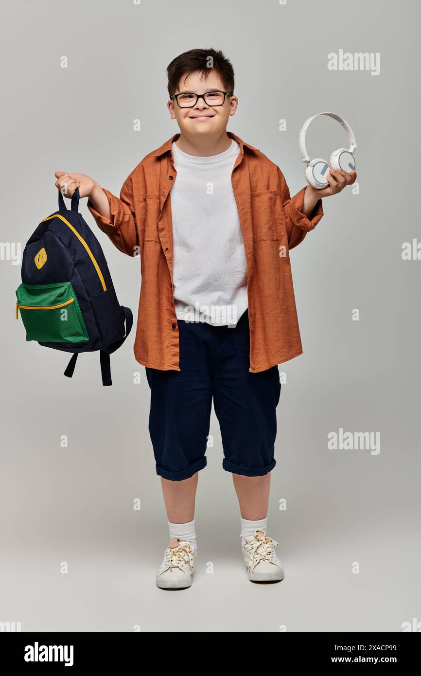 little kid with Down syndrome with backpack and headphones Stock Photo ...
