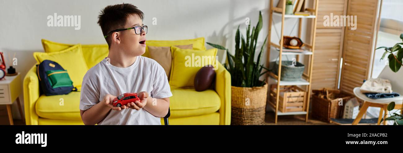 adorable child with Down syndrome immersed in a game with toy in cozy ...