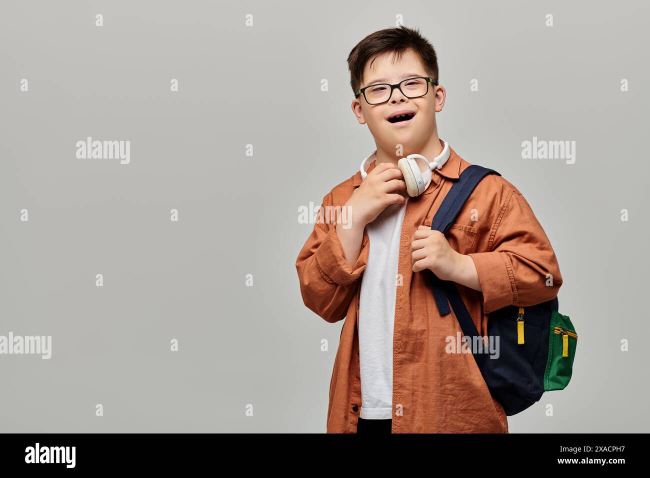 A kid with Down syndrome wearing glasses and a backpack Stock Photo - Alamy