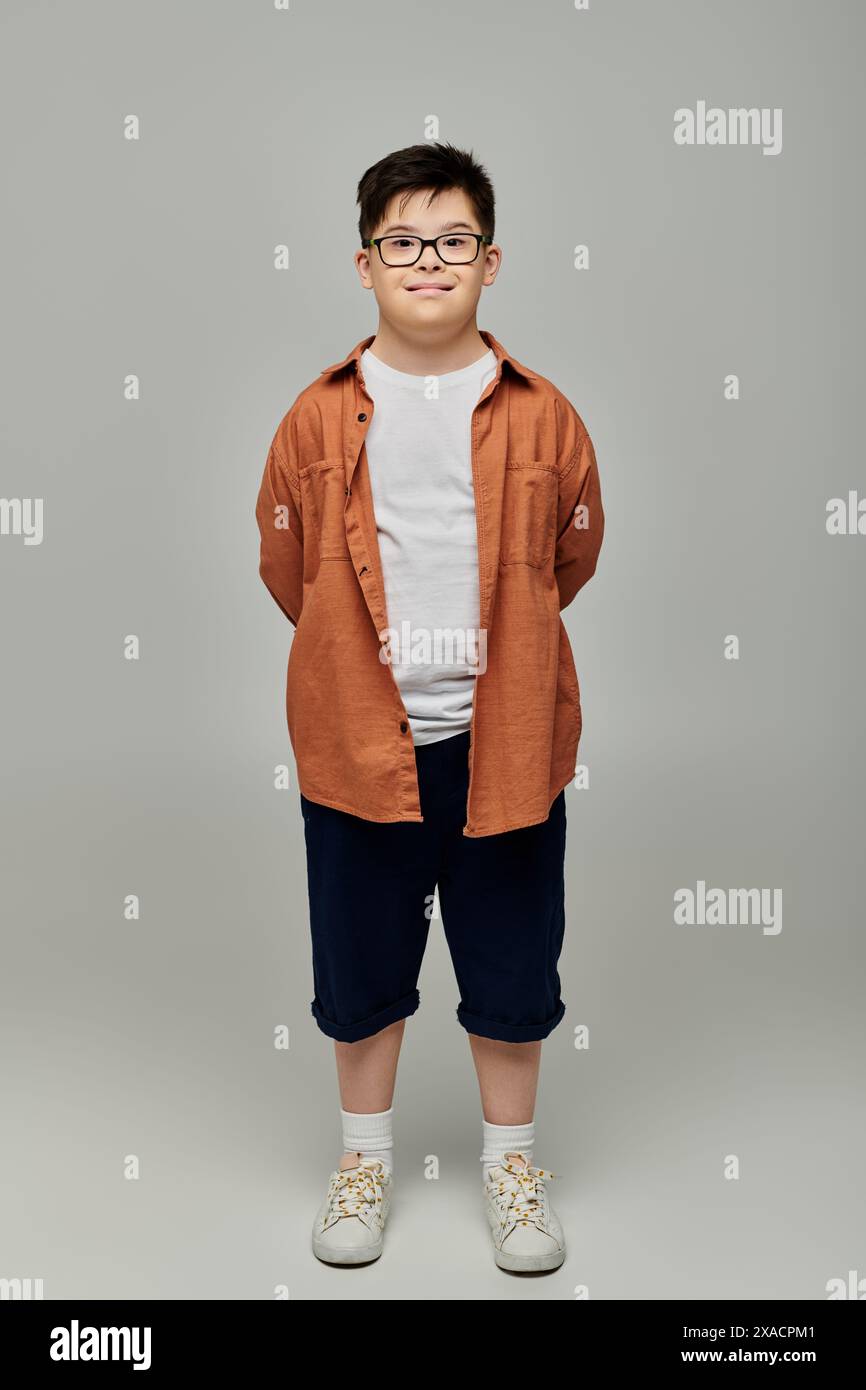 little kid with Down syndrome in glasses and shorts, standing ...
