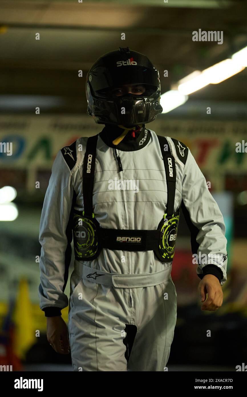 Professional Go Kart racer in helmet walking on a track mid race. Kyiv ...