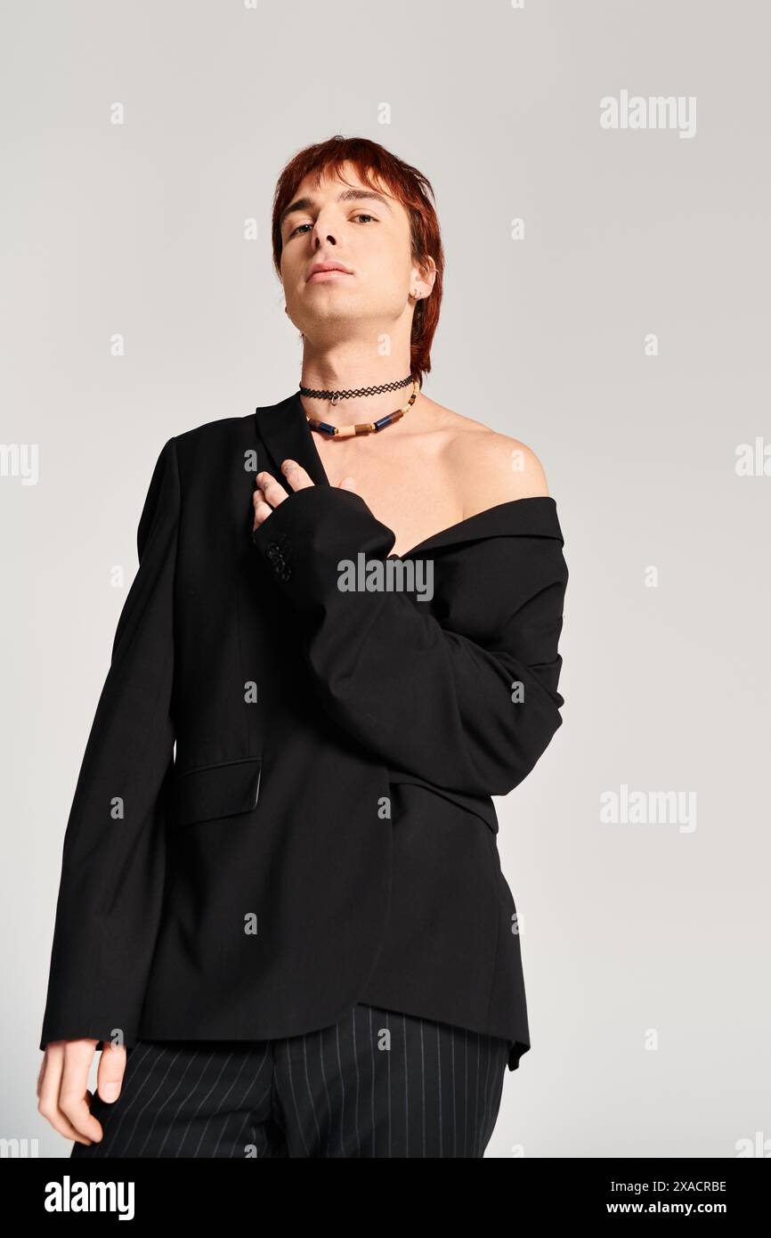 A daring man with striking red hair strikes a pose in a sleek black ...