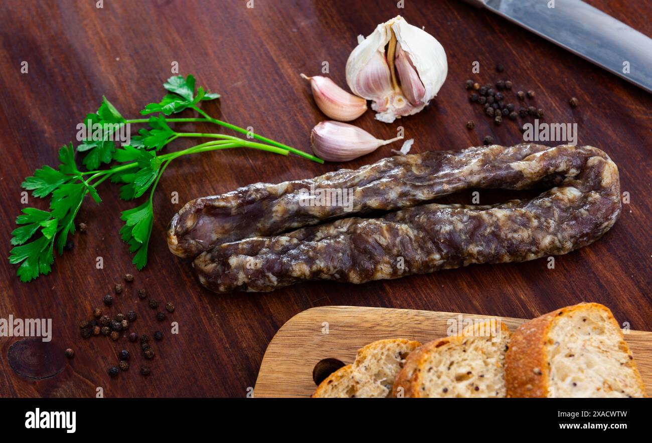 Dry pork sausage with condiments on table Stock Photo - Alamy