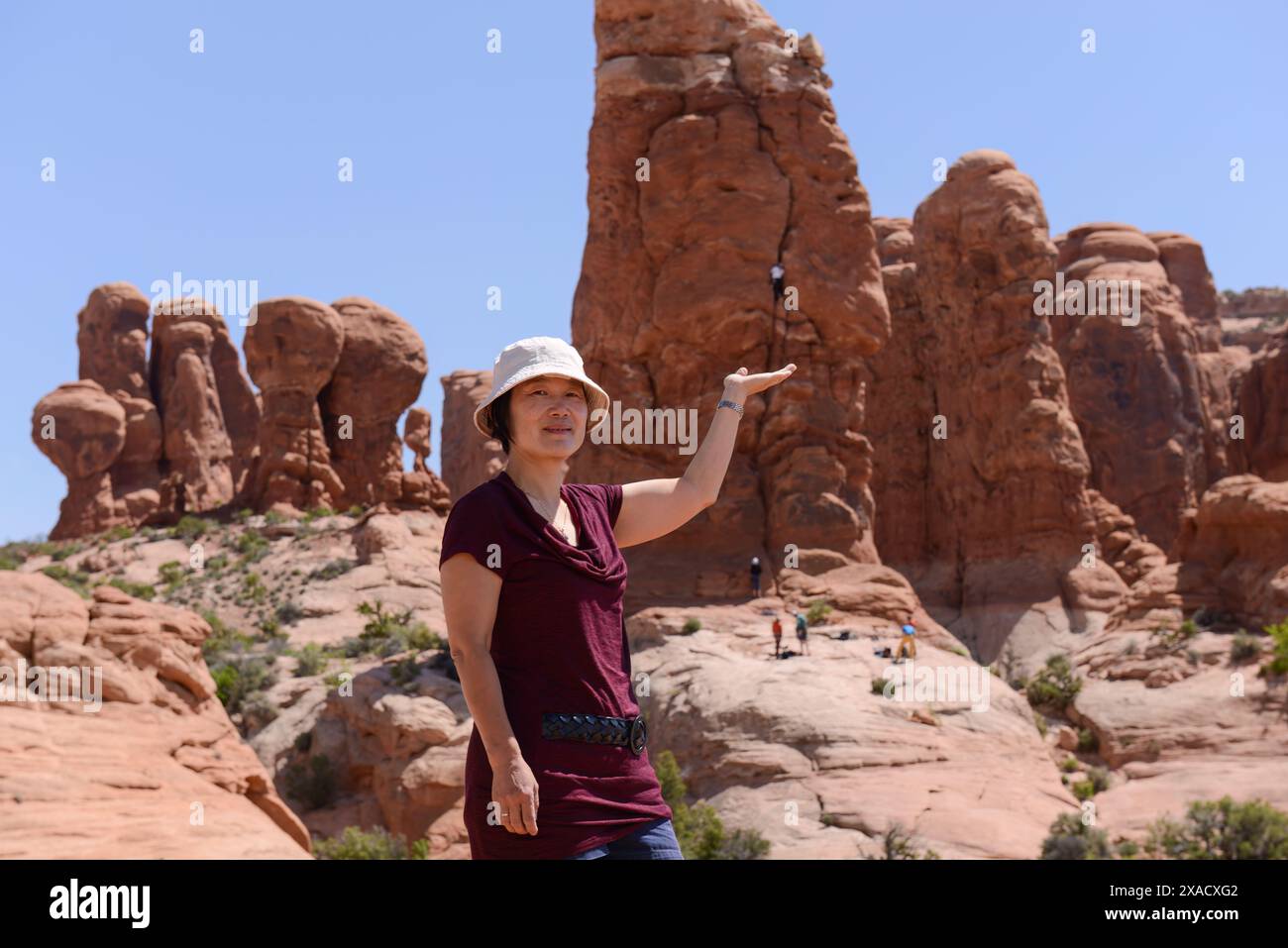 Female tourist posing for fun photos. Hand holding unrecognizable rock ...