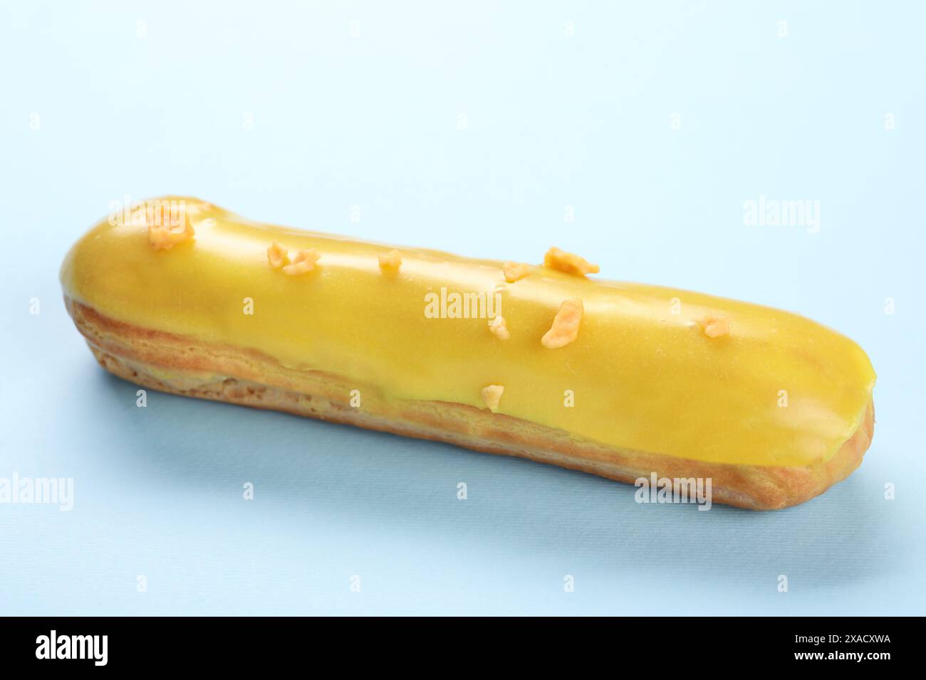 Delicious eclair covered with glaze on light blue background Stock ...