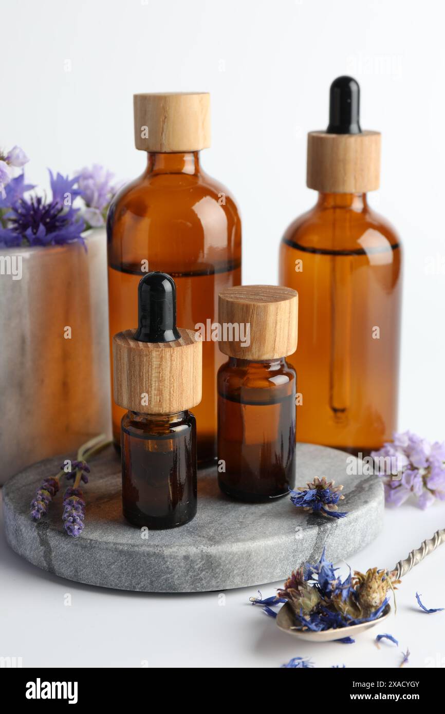 Aromatherapy. Different essential oils and flowers on white background ...