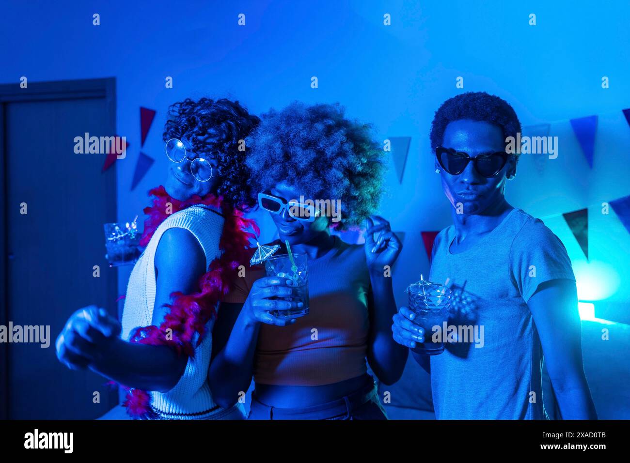 Multi-ethnic students partying at home at night with colorful neon ...