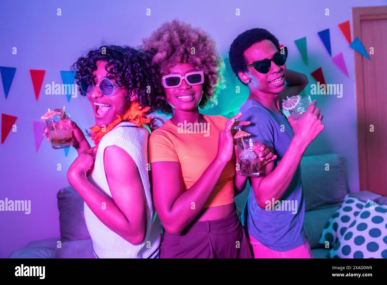 Three happy multi-ethnic friends partying at night with colorful neon ...