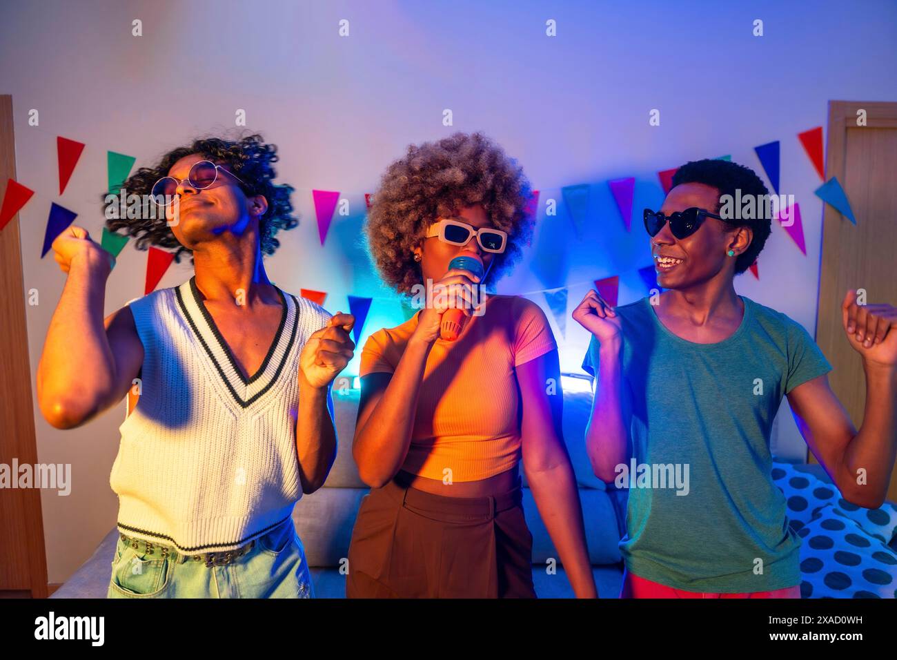Afro cool woman singing karaoke and partying with friends at home at ...