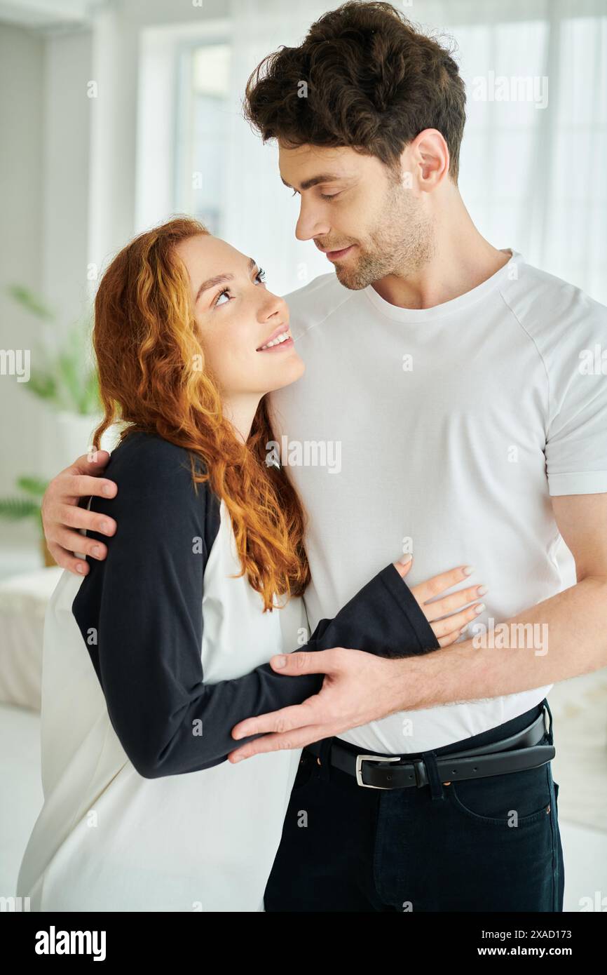 A man and woman, entwined in a warm embrace, express their love and ...