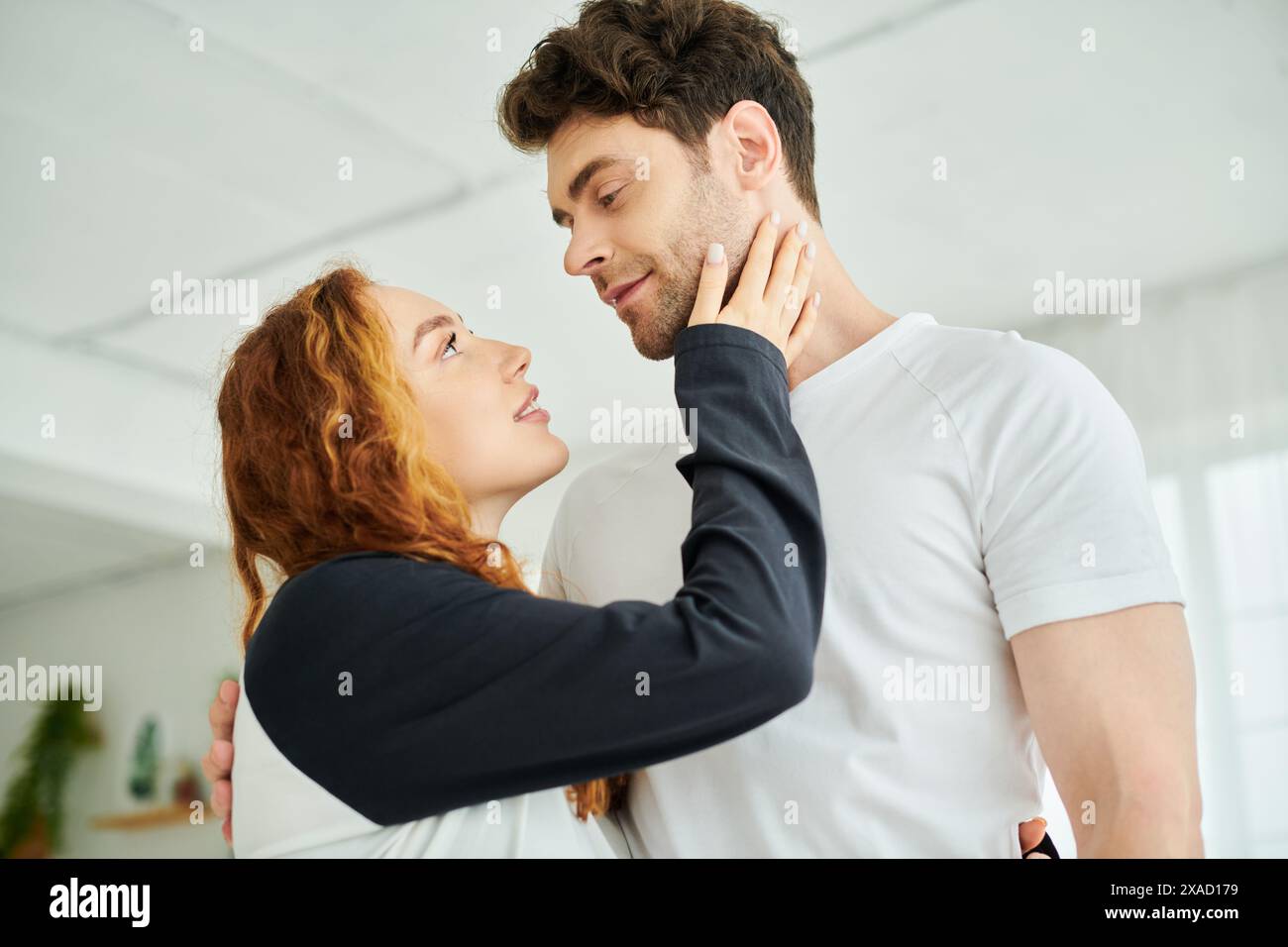 A man and a woman gaze at each other, locked in a silent moment of ...