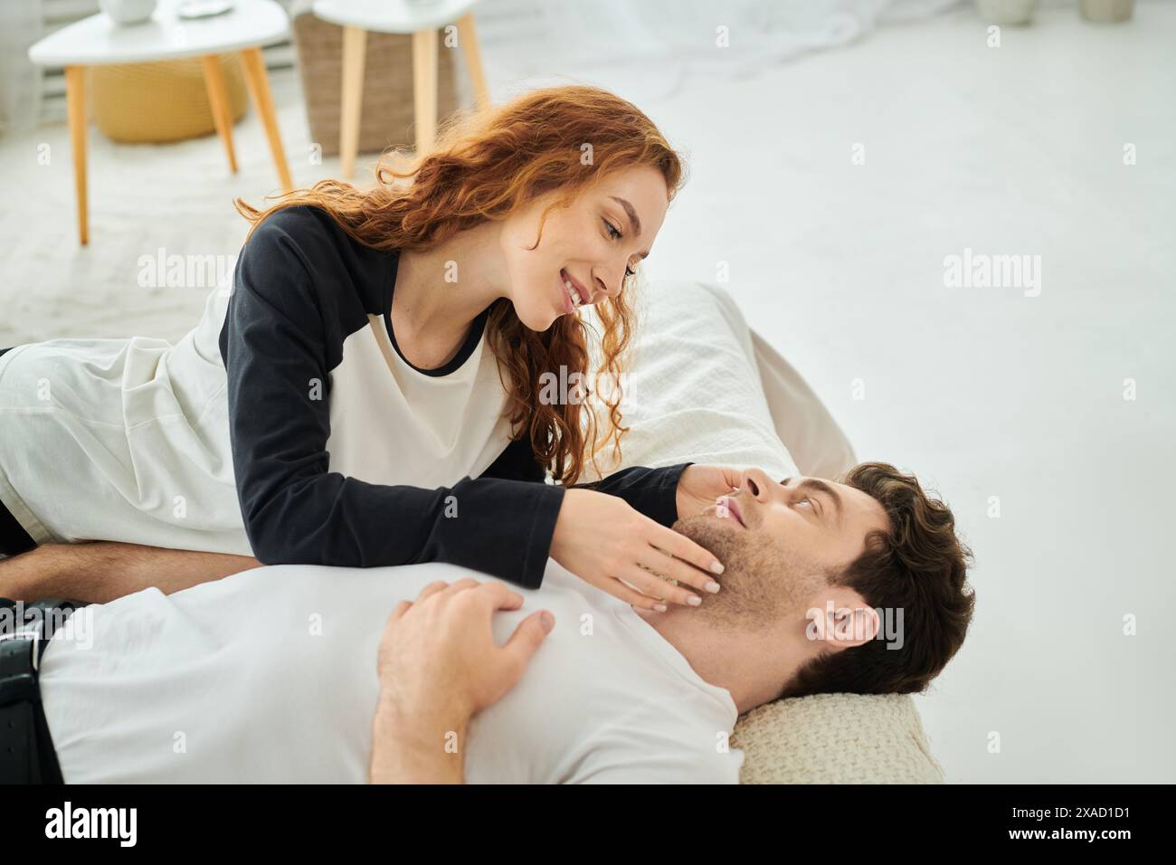 A man and a woman, deeply in love, lay intertwined on a cozy bed ...