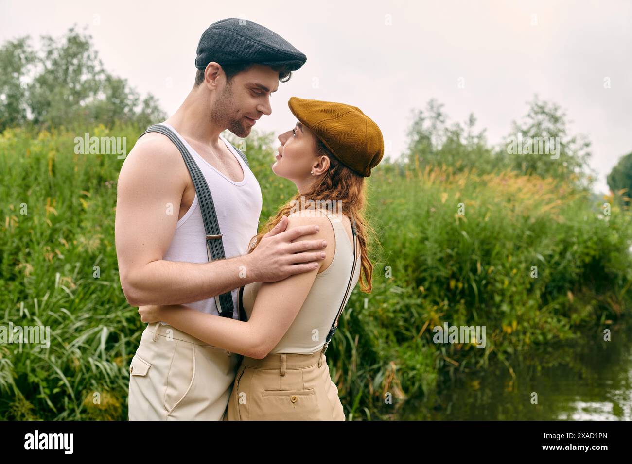 A man and woman stand close to each other in a green park, their ...