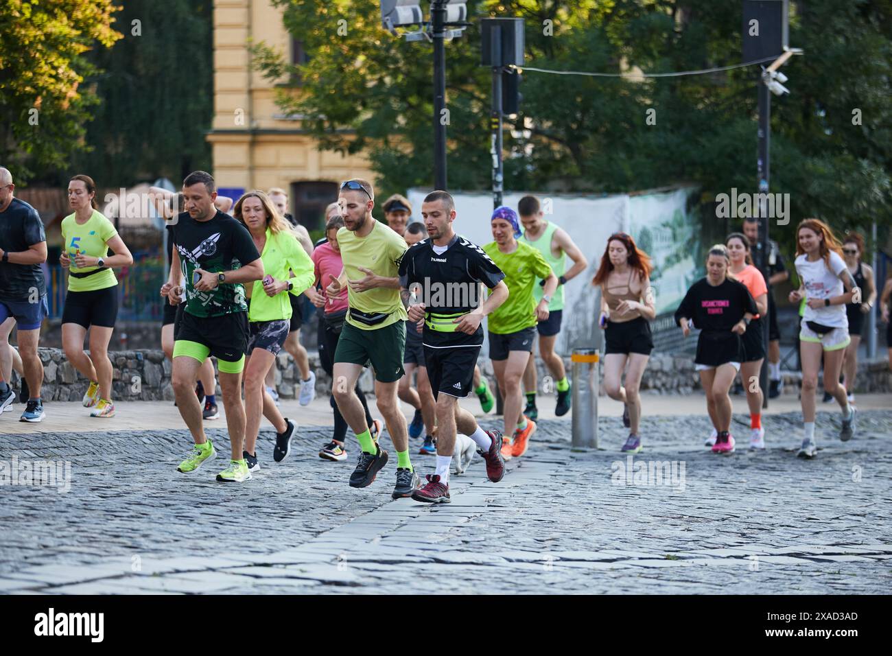 Group of runners running urban marathon up the hill in the morning ...