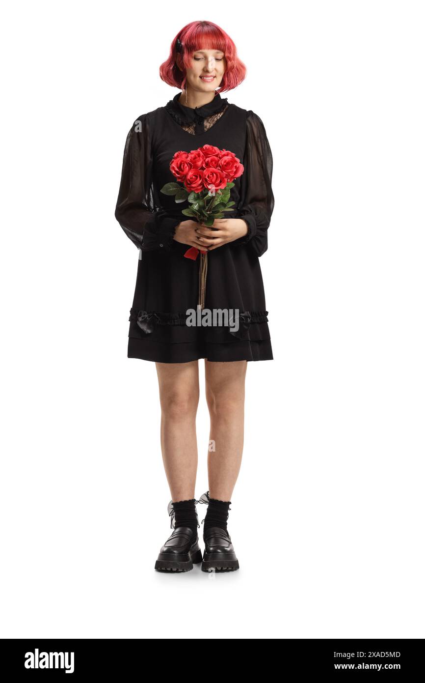 Full length portrait of a young woman in a black dress looking at a ...