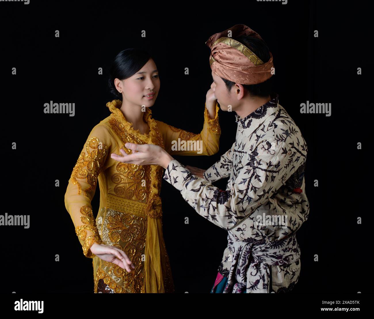 Indonesian man and woman in traditional attire performing a cultural ...